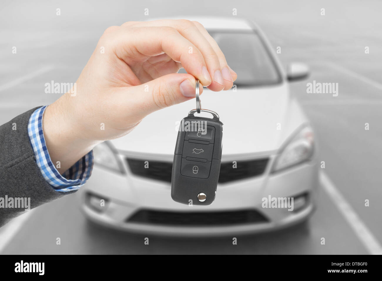 Male holding car keys with parked car on background Stock Photo - Alamy