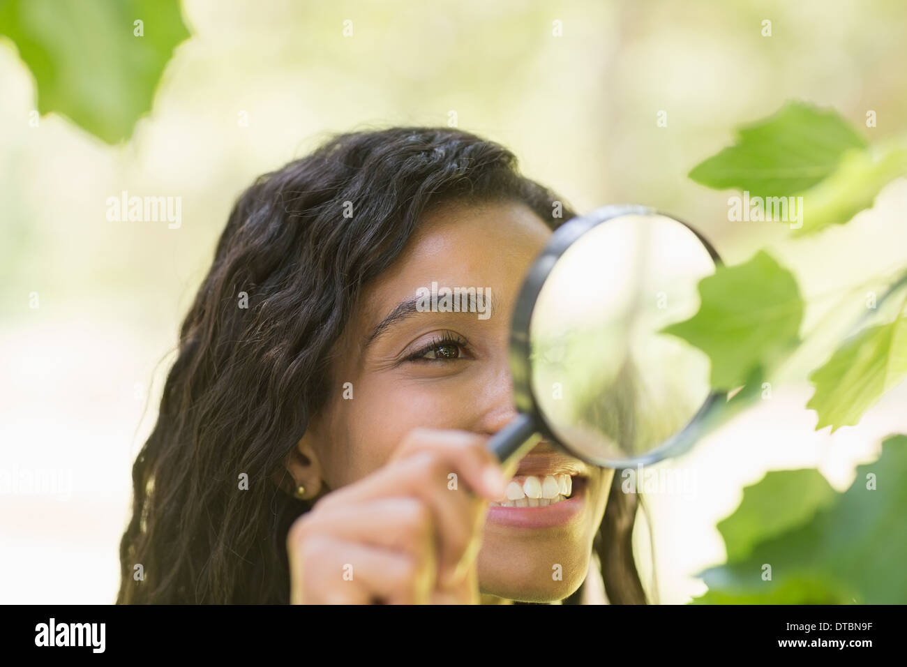 Woman examining leaves with magnifying glass Stock Photo - Alamy