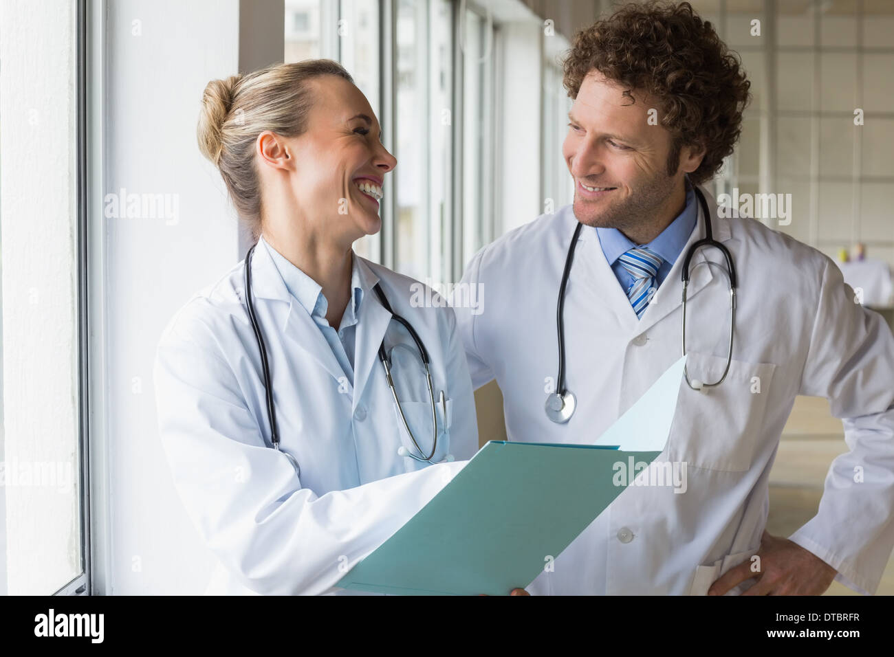 Happy doctors discussing over file on hospital Stock Photo - Alamy