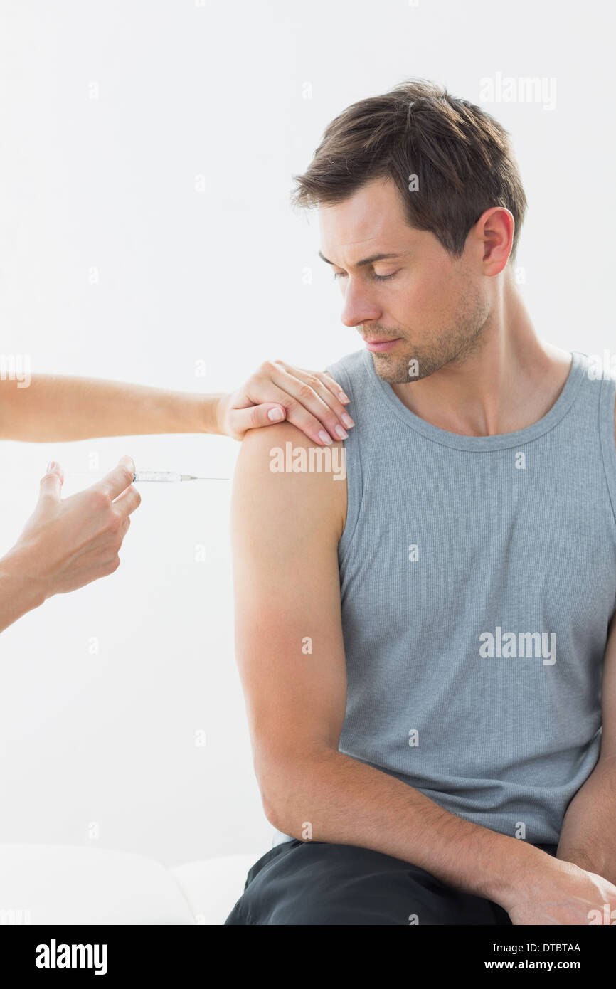 Doctor injecting man on arm in clinic Stock Photo - Alamy