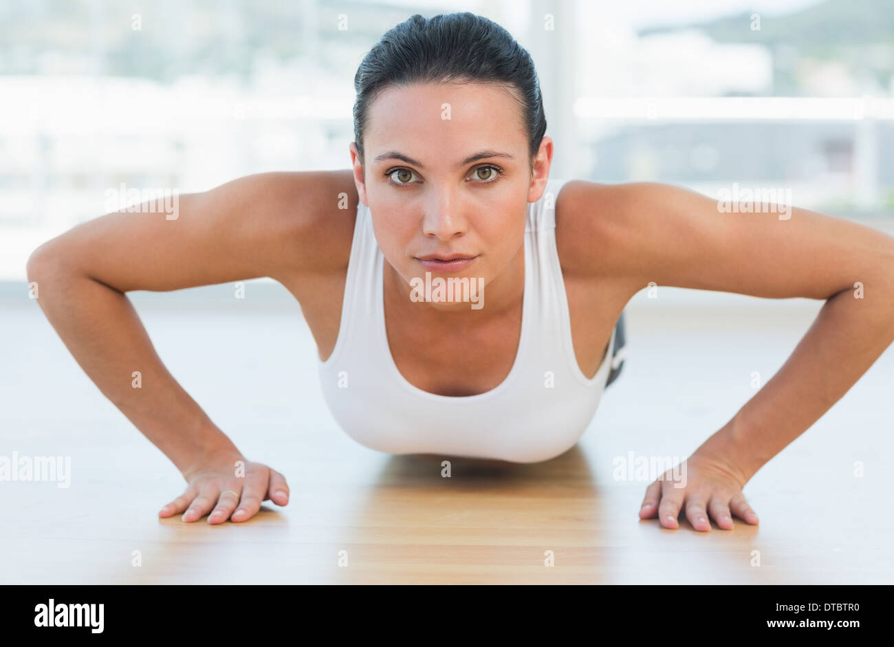 Determined beautiful woman doing push ups in gym Stock Photo - Alamy