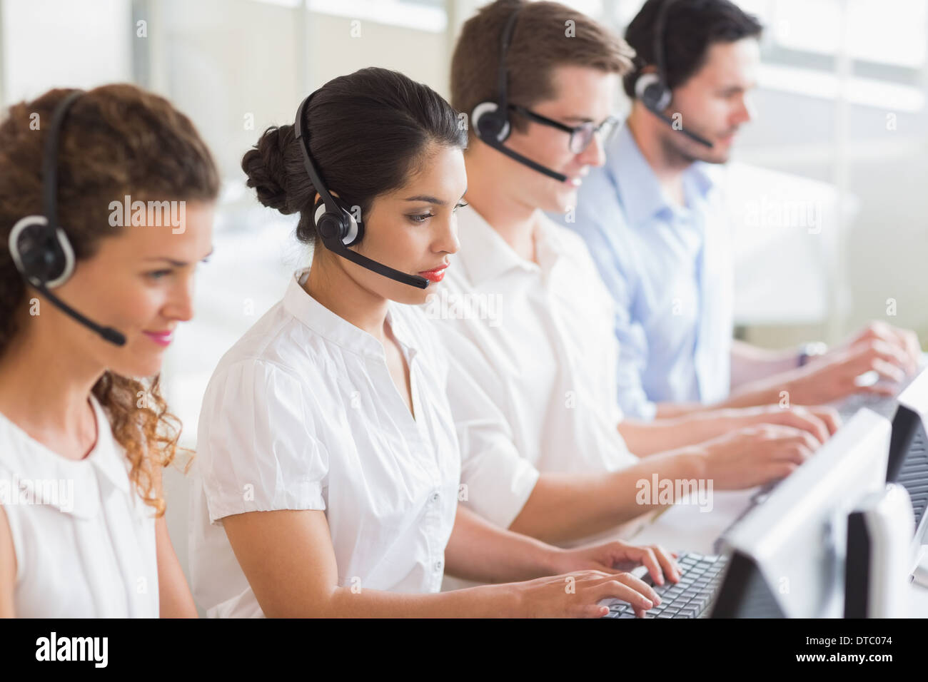 Customer service operators working at desk Stock Photo - Alamy