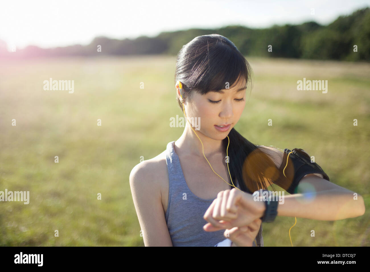 Young female runner checking watch for time Stock Photo - Alamy