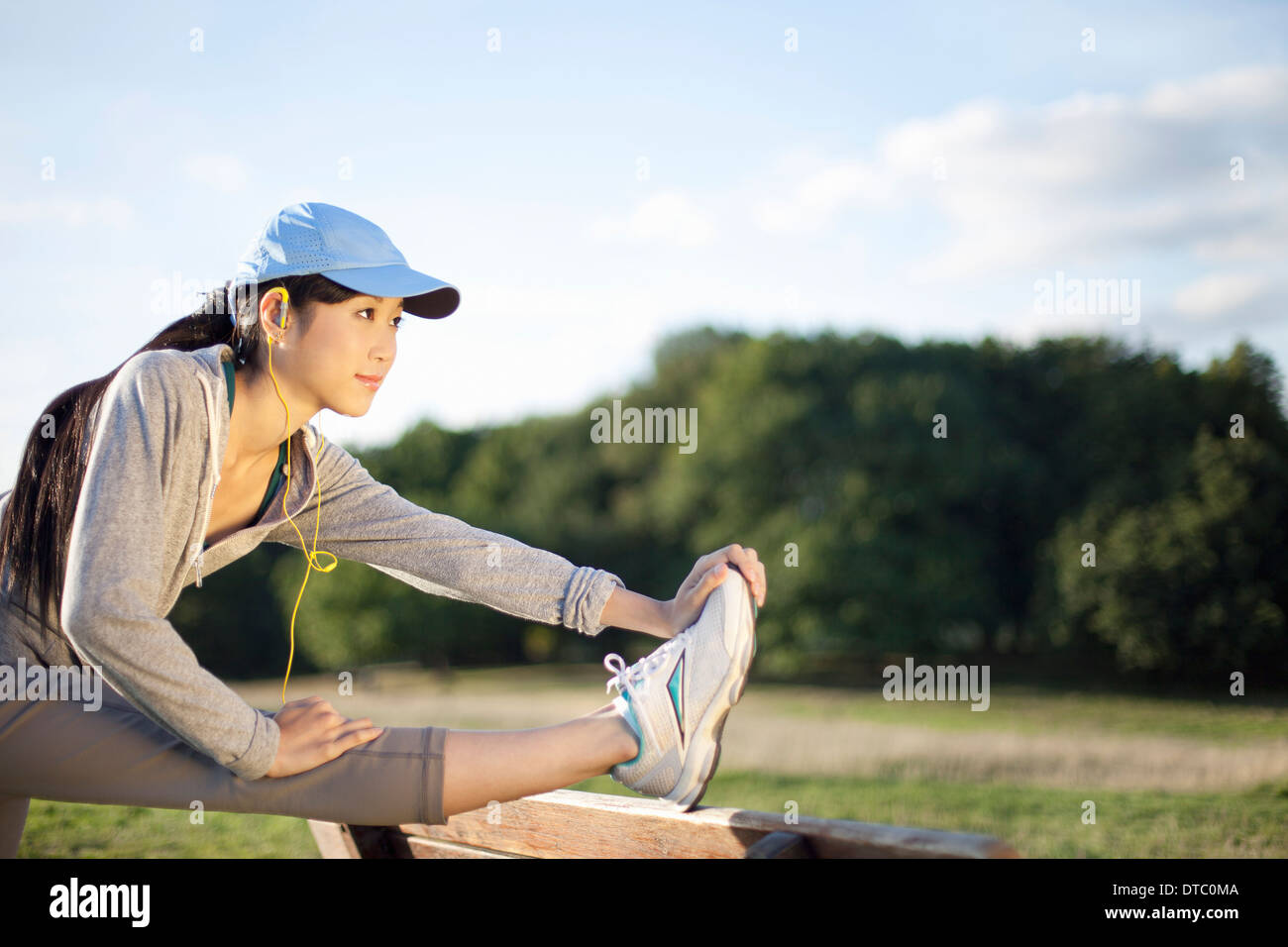 Young female runner stretching legs Stock Photo - Alamy