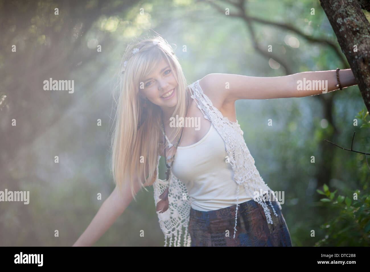 Portrait of teenage girl holding onto tree in woodland Stock Photo - Alamy