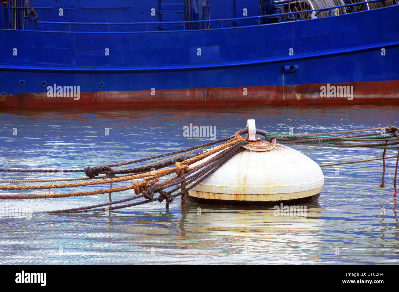 rusty buoy with lot of ropes and a ship on port Stock Photo - Alamy