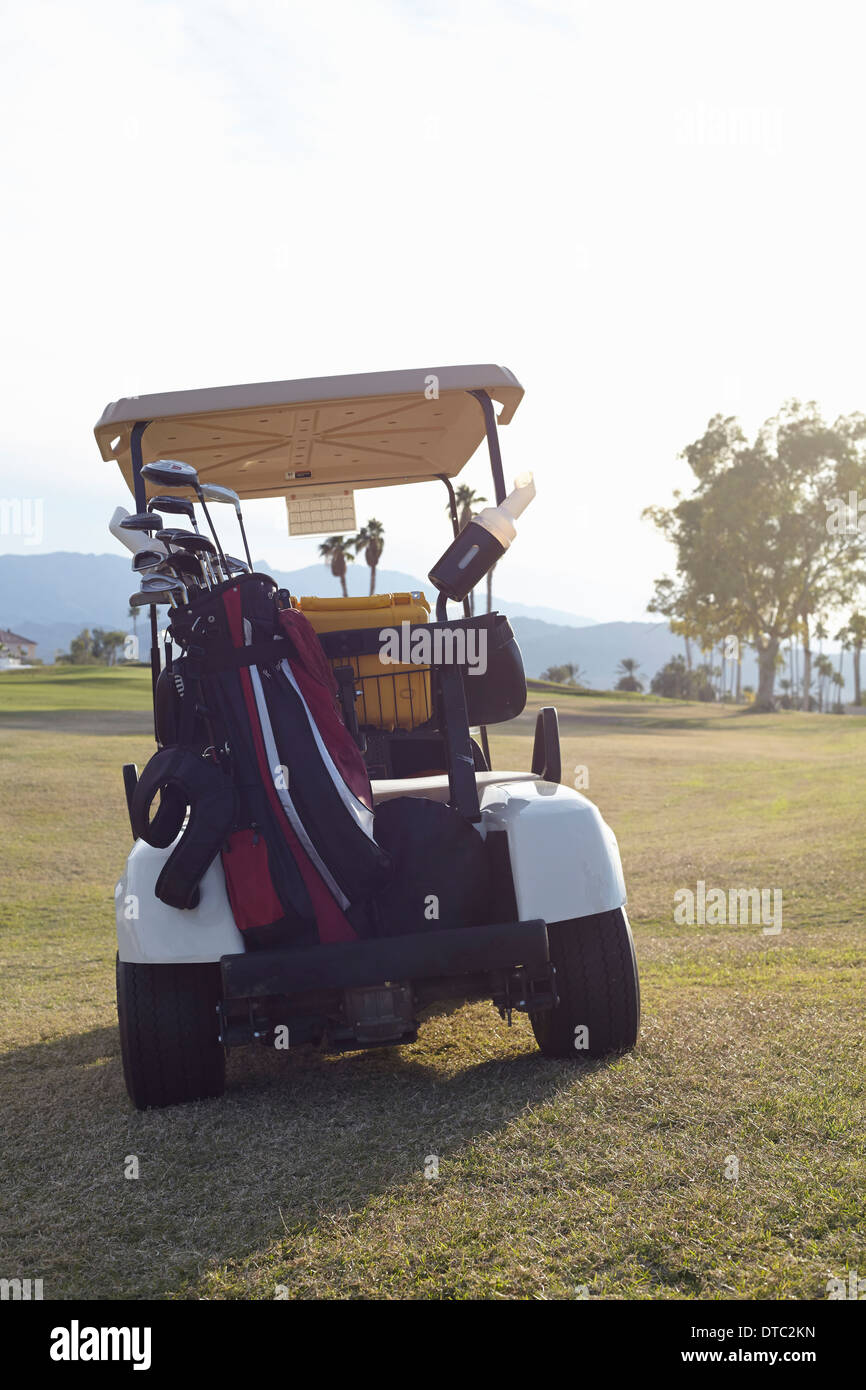 Parked golf buggy on green Stock Photo - Alamy
