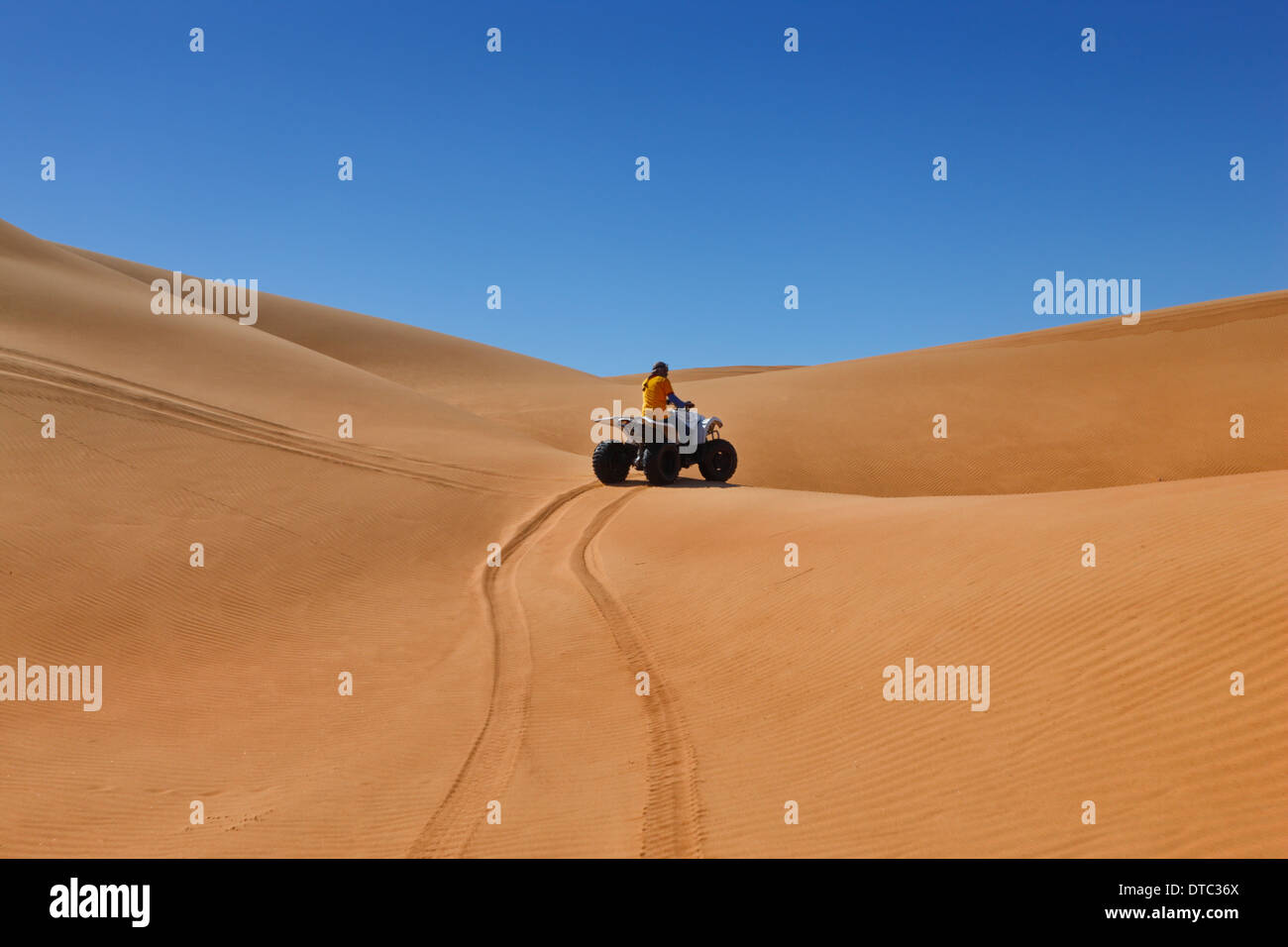 Quad driving in Dubai desert Stock Photo - Alamy