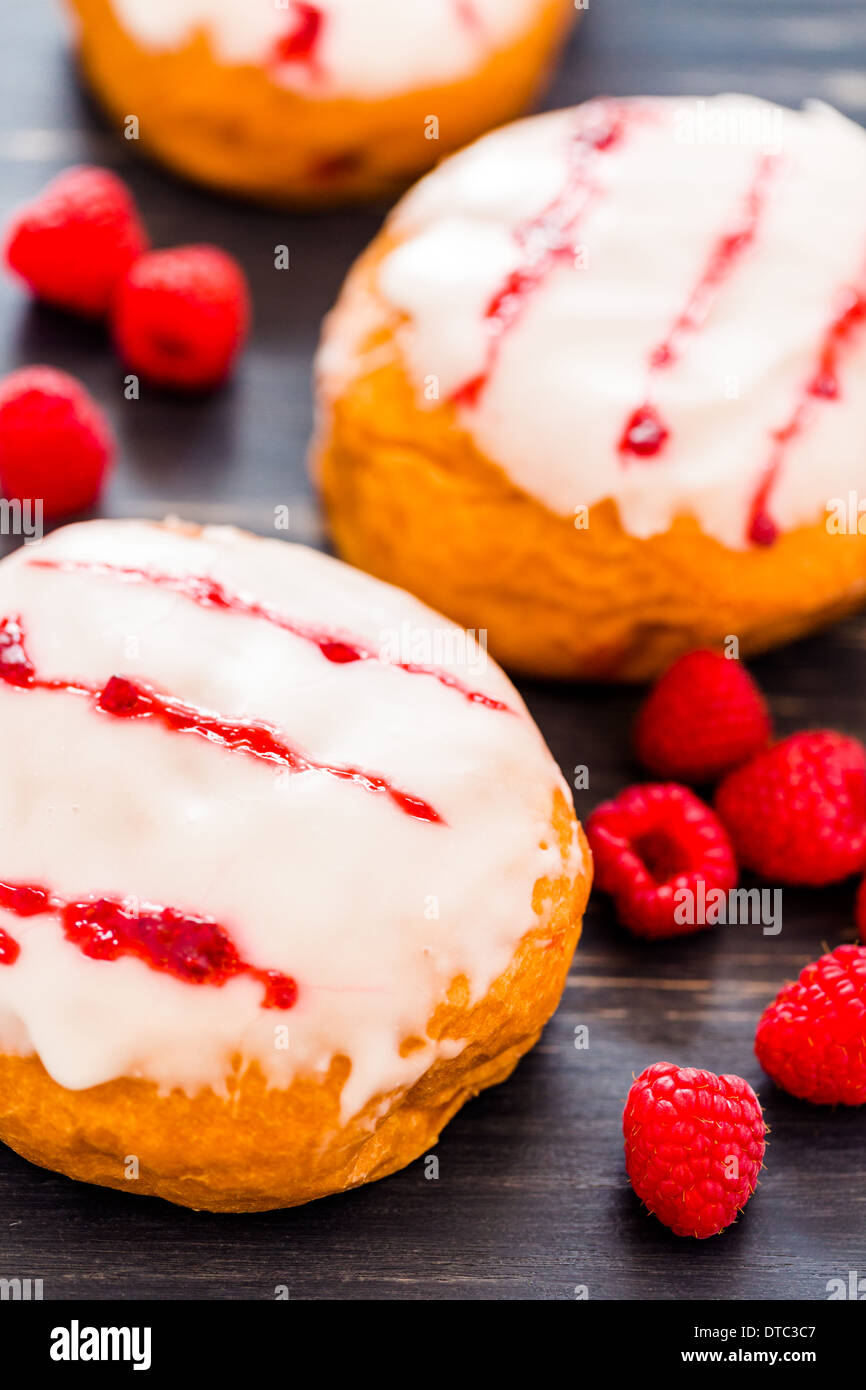 Fresh raspberry jelly filled donuts with white glazing on top Stock Photo - Alamy