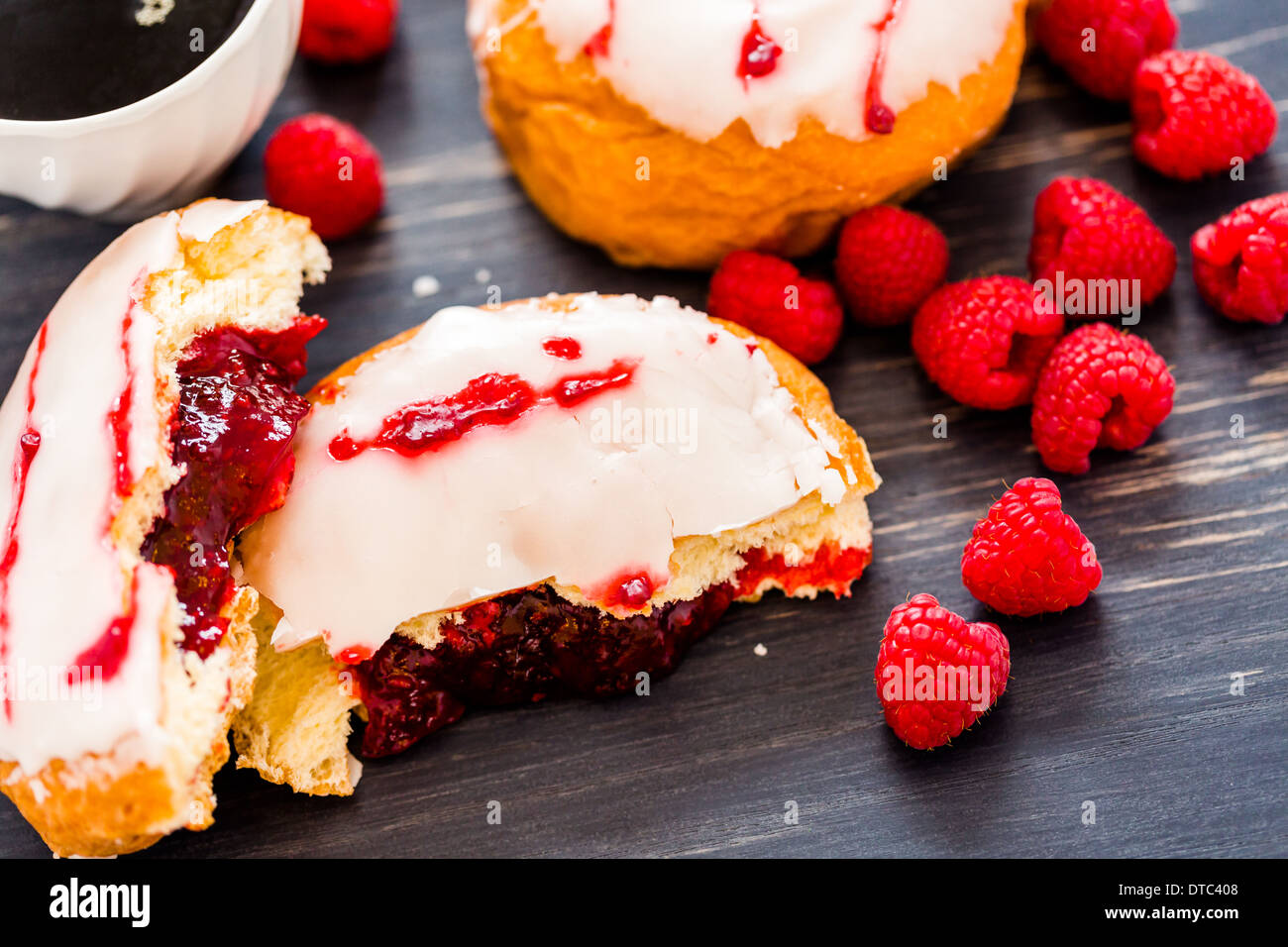 Fresh raspberry jelly filled donuts with white glazing on top Stock Photo - Alamy