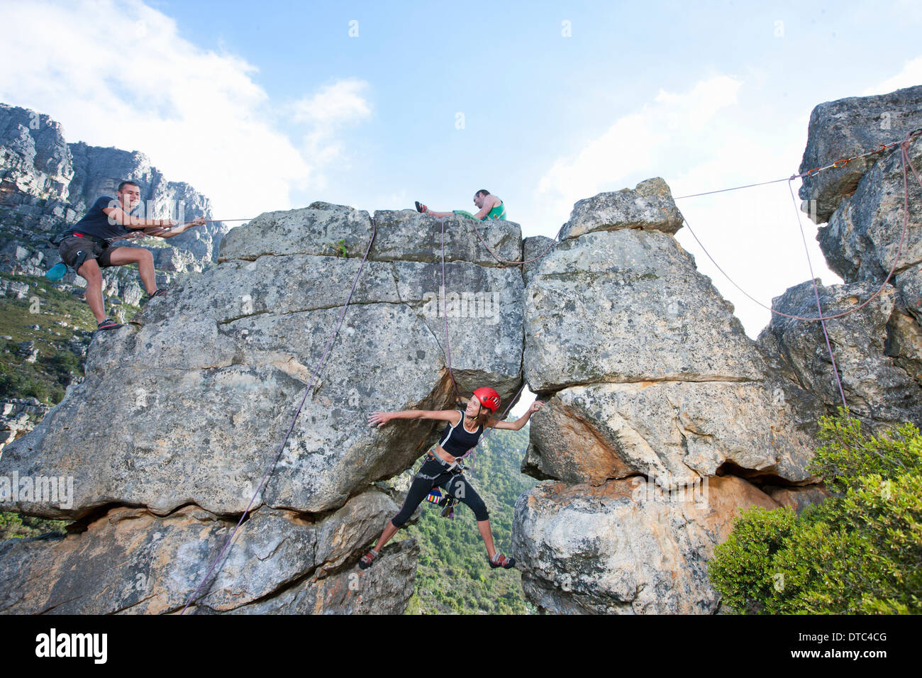 Three rock climbers climbing up rock formation Stock Photo - Alamy