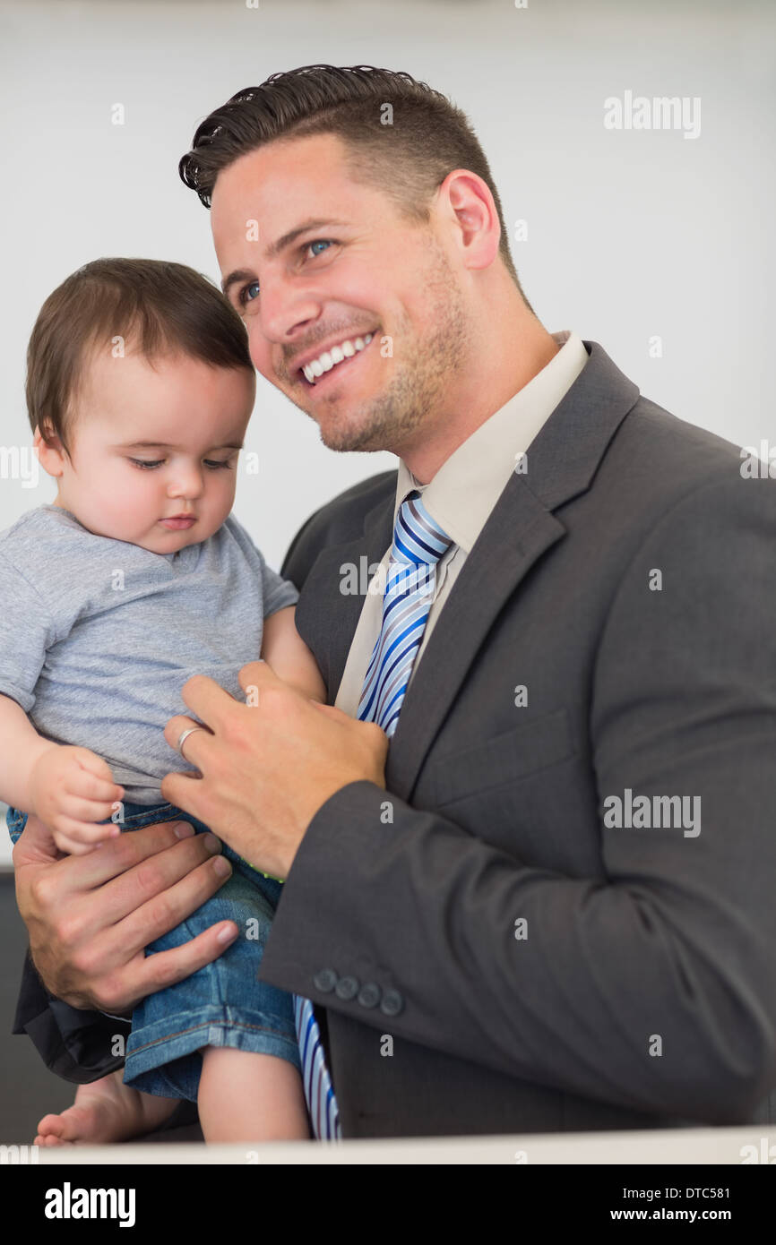 Businessman carrying baby boy at home Stock Photo - Alamy