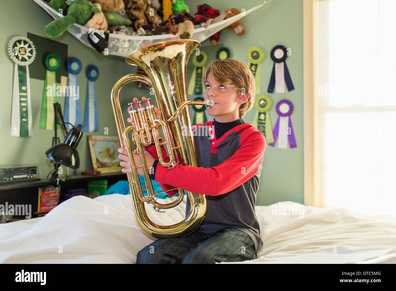 Boy playing tuba in bedroom Stock Photo - Alamy