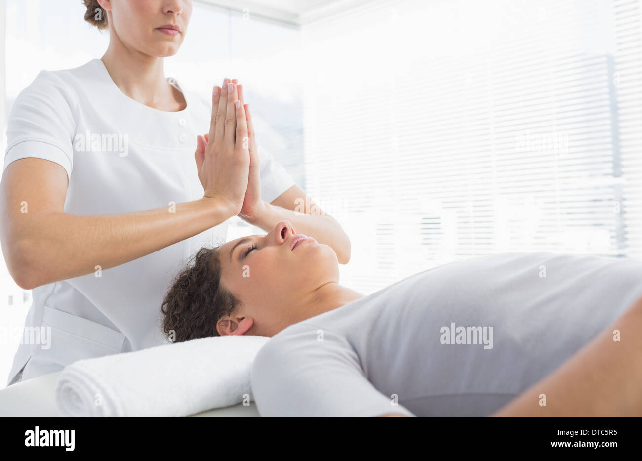 Therapist giving Reiki treatment to woman Stock Photo - Alamy