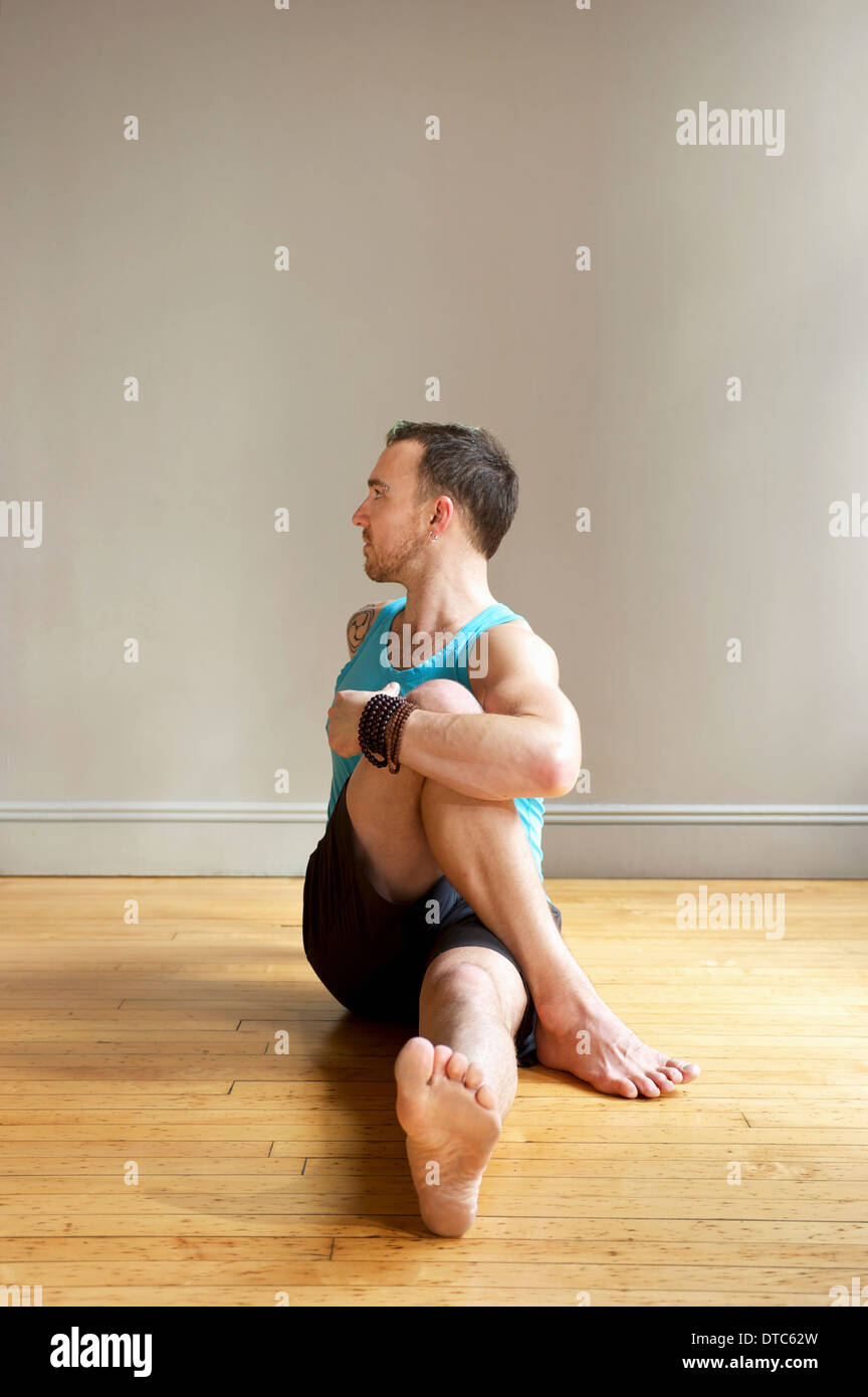 Mid adult man twisting back Stock Photo - Alamy