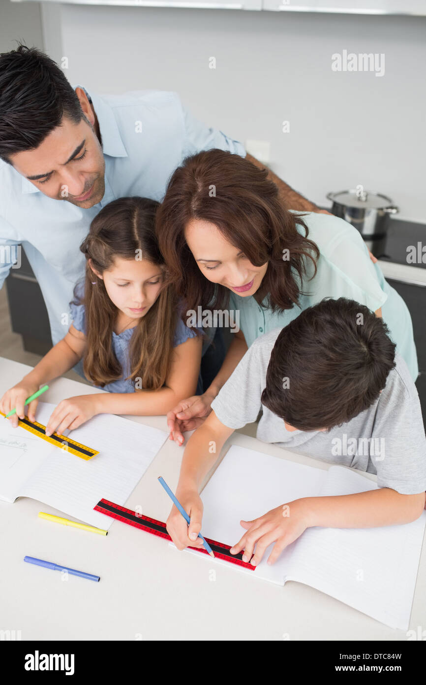 Couple helping kids with their homework Stock Photo - Alamy