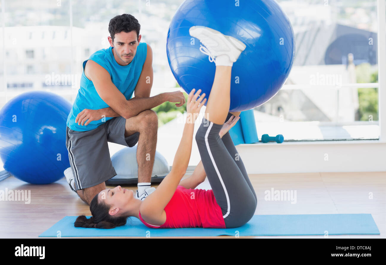 Trainer helping woman with her exercises at gym Stock Photo - Alamy