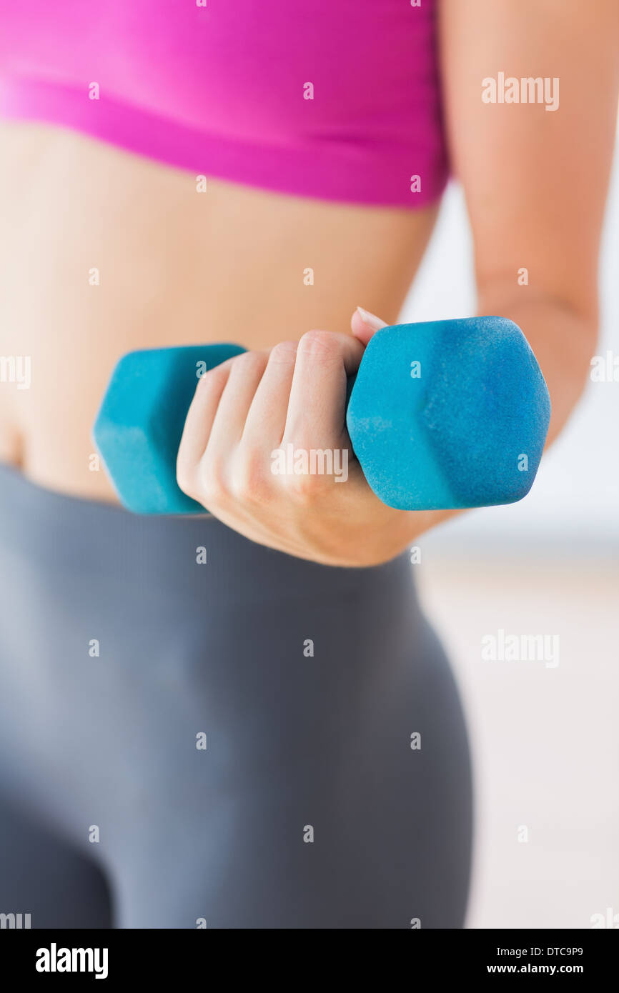 Mid section of a woman lifting dumbbell weight Stock Photo - Alamy