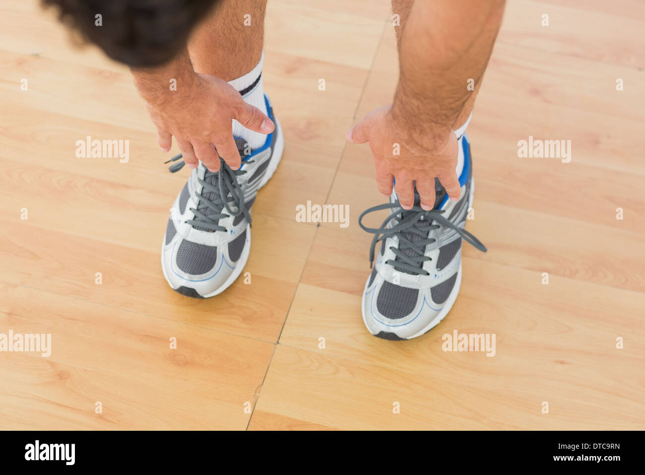 sporty man stretching hands to legs in fitness studio Stock Photo - Alamy