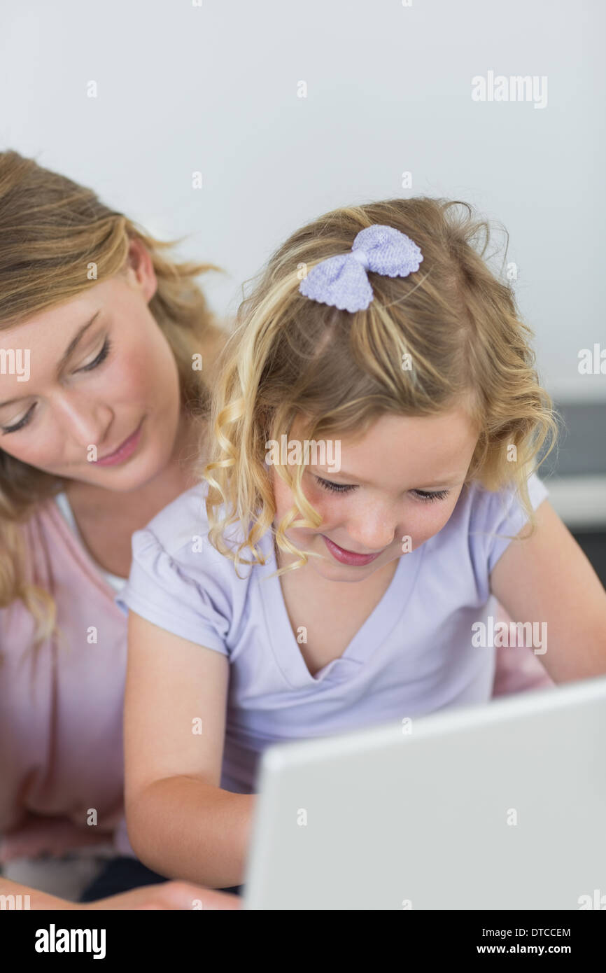 Girl using laptop with mother Stock Photo - Alamy