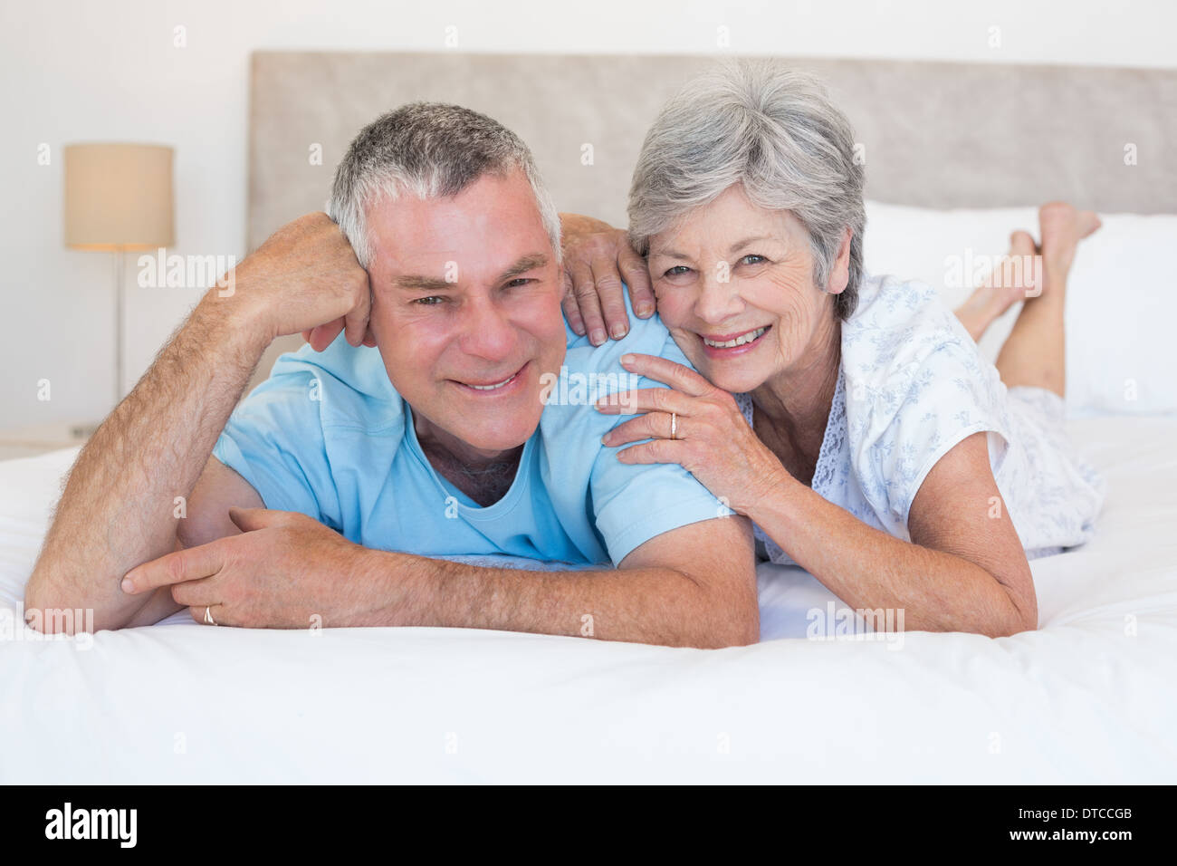 Loving senior couple lying in bed Stock Photo - Alamy