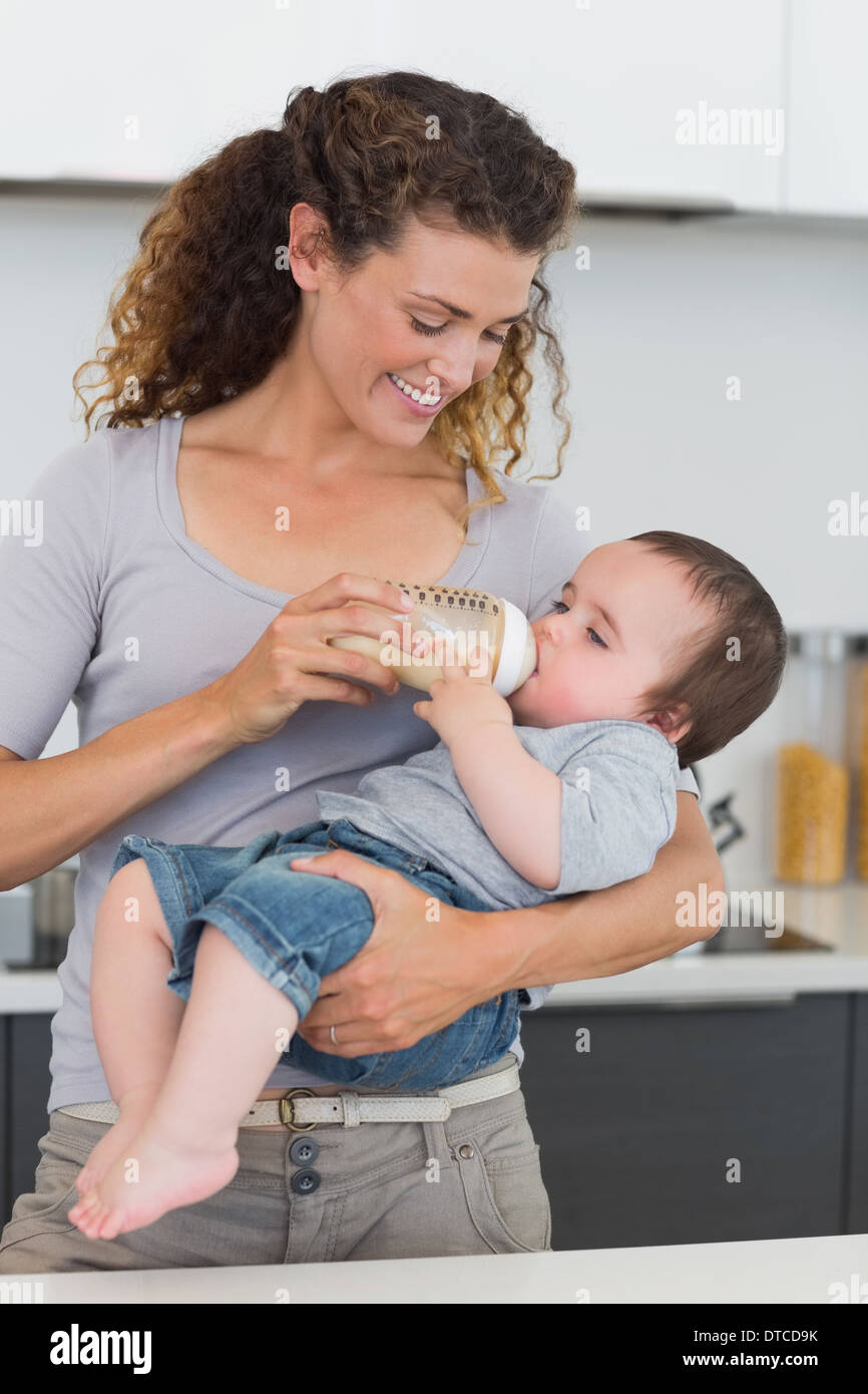 Woman feeding milk to baby Stock Photo - Alamy