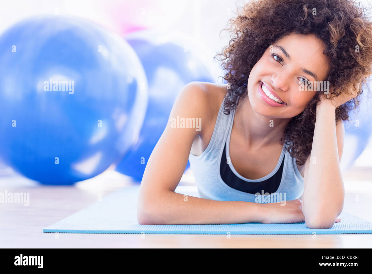 Fit woman lying on exercise mat in fitness studio Stock Photo - Alamy