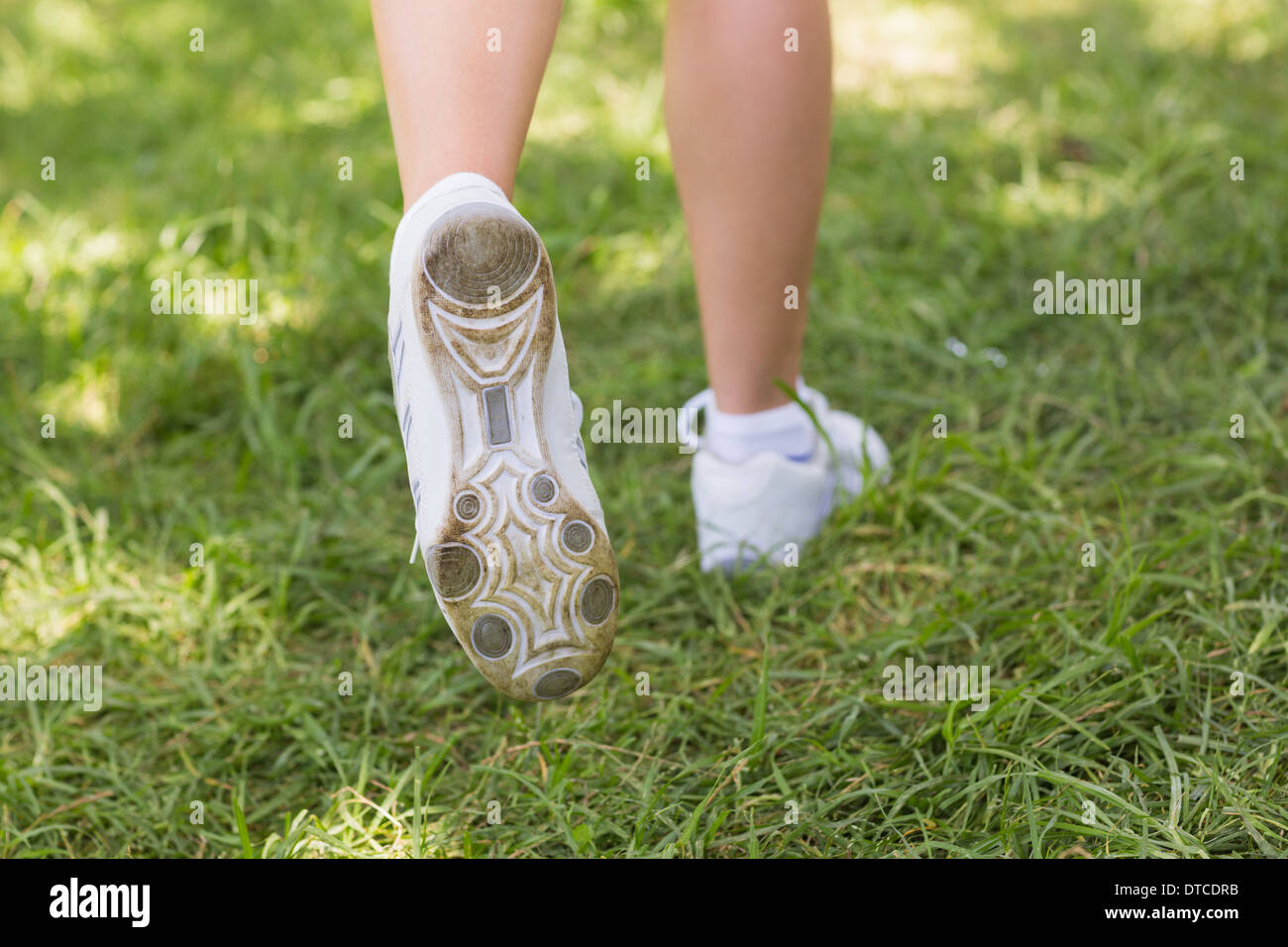 Low section of woman in sports shoes jogging at park Stock Photo - Alamy
