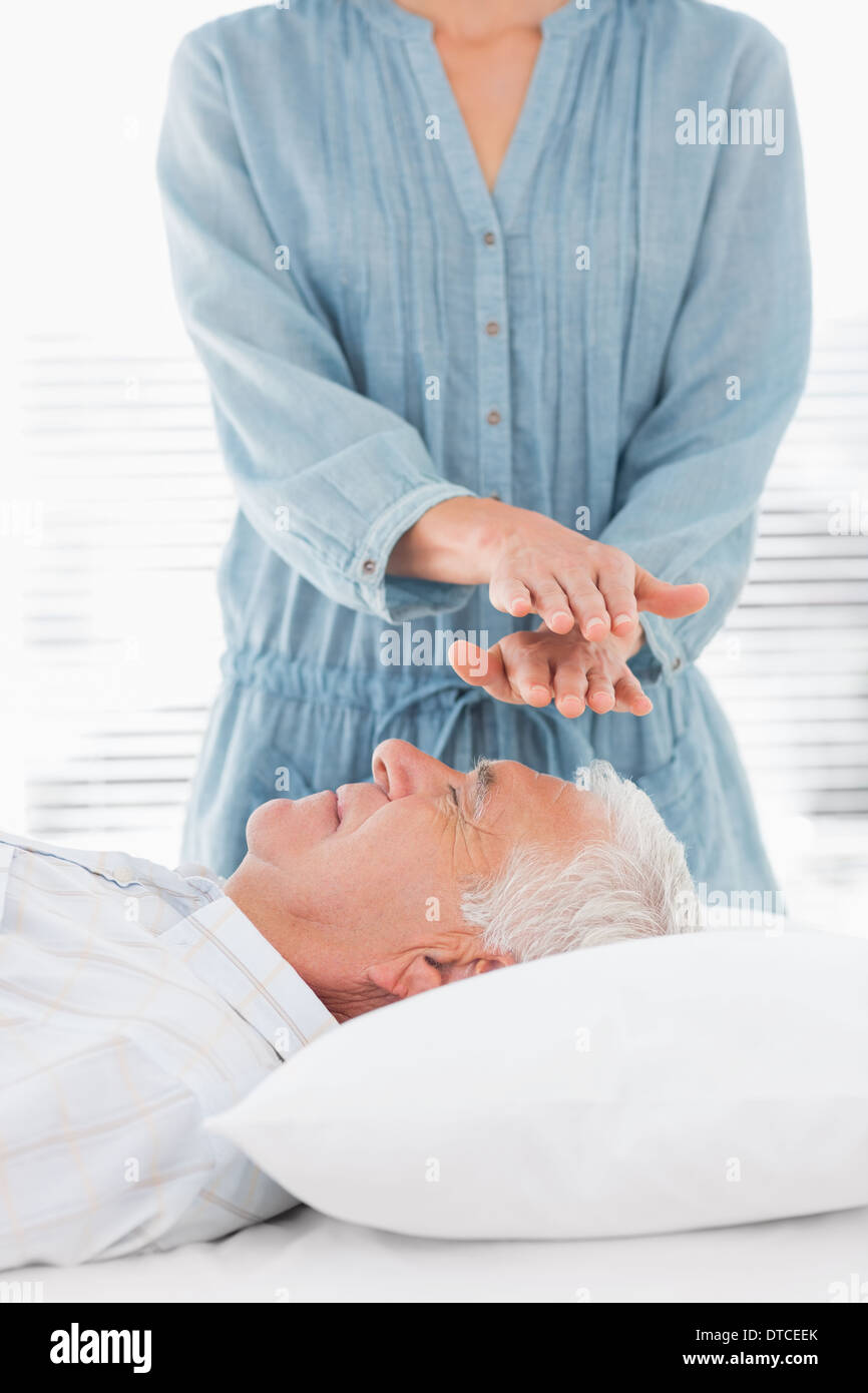 Therapist performing Reiki over forehead of man Stock Photo - Alamy