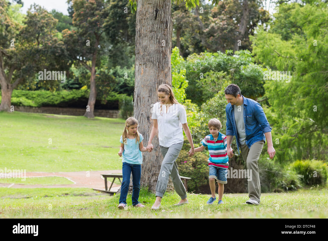 Parents and kids walking in park Stock Photo - Alamy