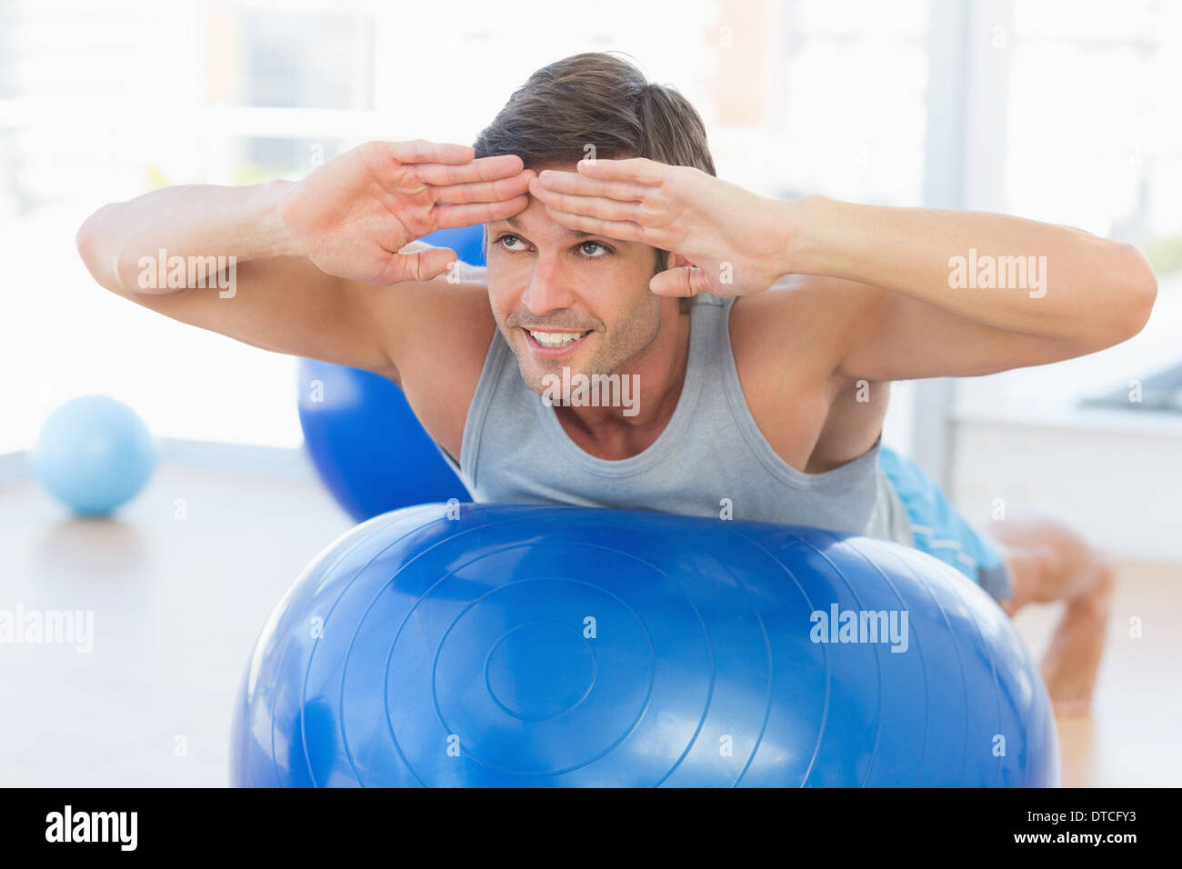 Happy fit man stretching on exercise ball Stock Photo - Alamy