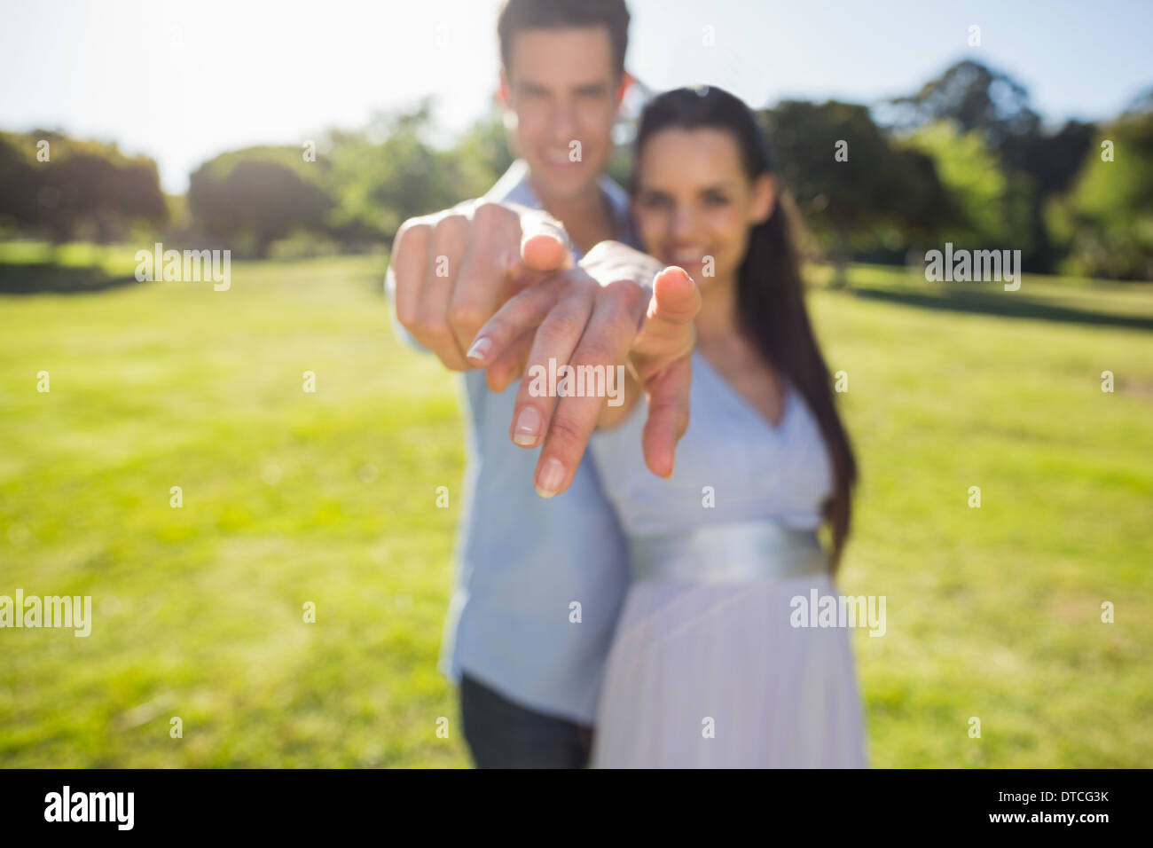 Young couple pointing finger to the camera at park Stock Photo - Alamy