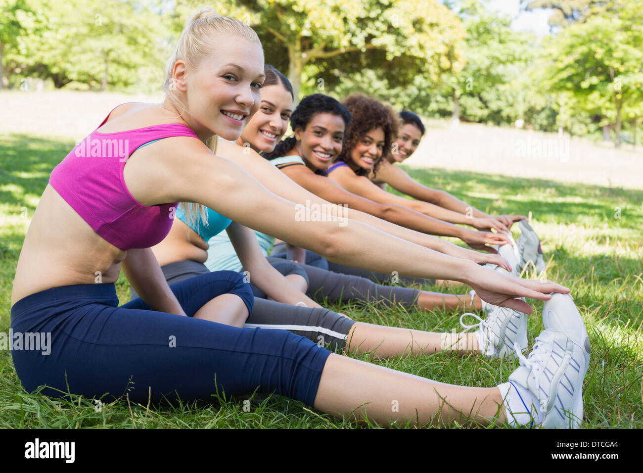 Women performing stretching exercise at park Stock Photo - Alamy