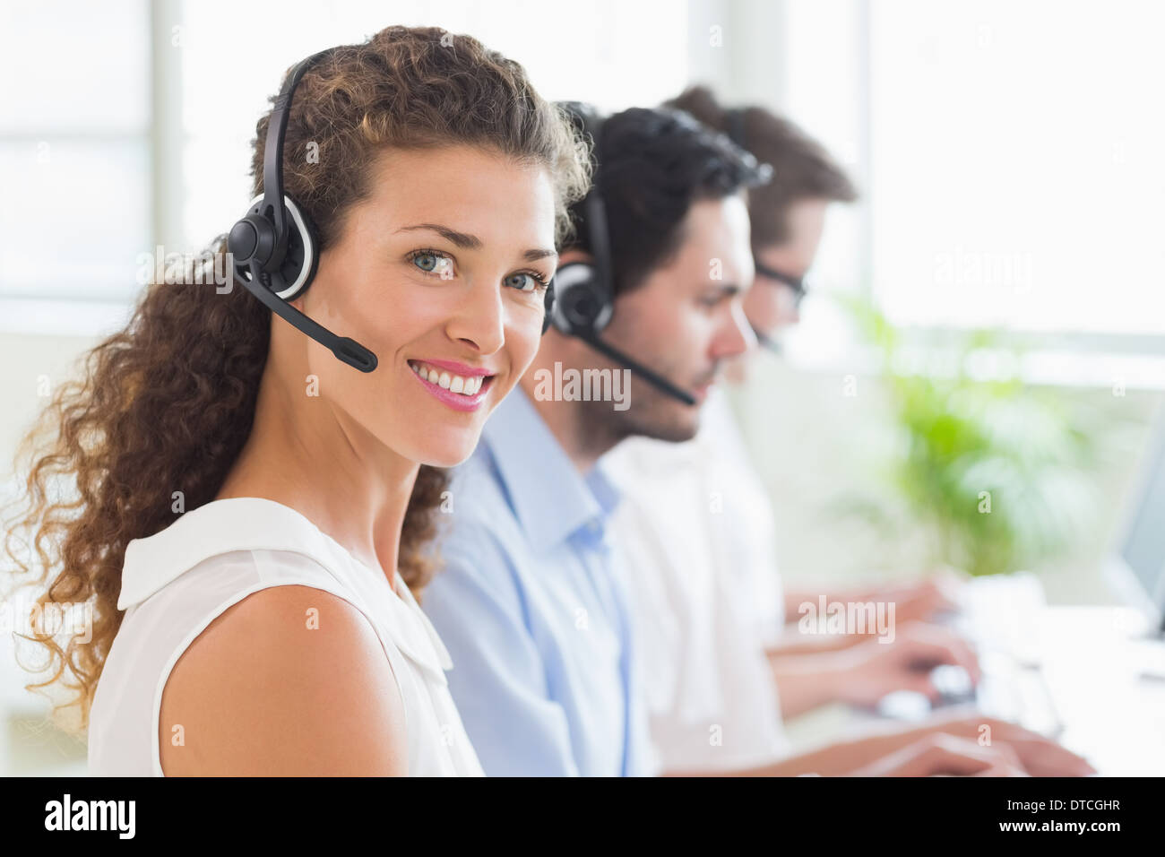 Call center operator wearing headset in office Stock Photo - Alamy