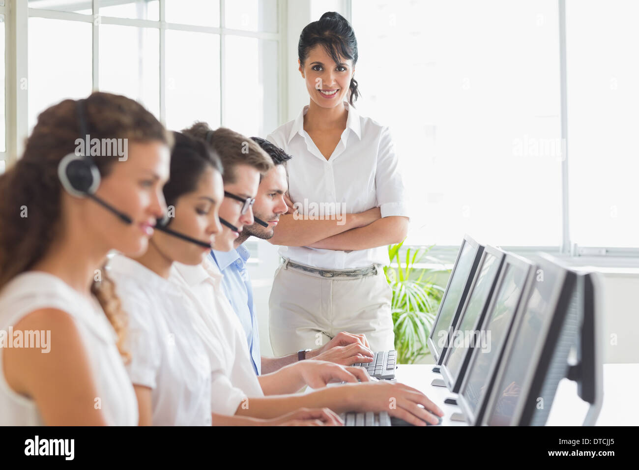 Happy manager working in a call center Stock Photo - Alamy