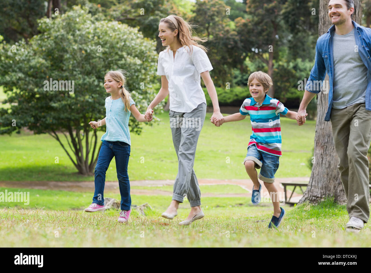 Parents and kids walking in park Stock Photo - Alamy