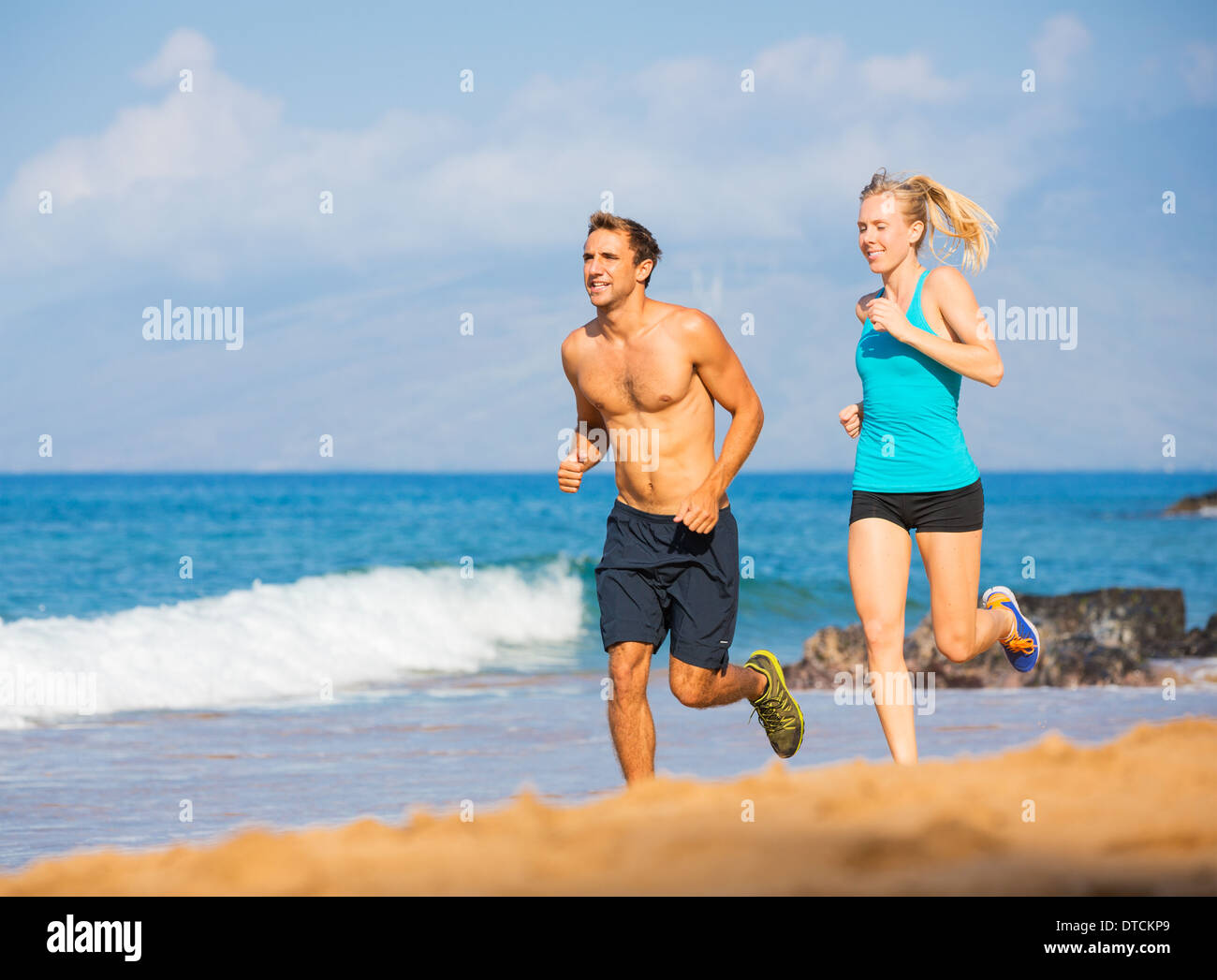 Athletic attractive couple running on beach Stock Photo - Alamy