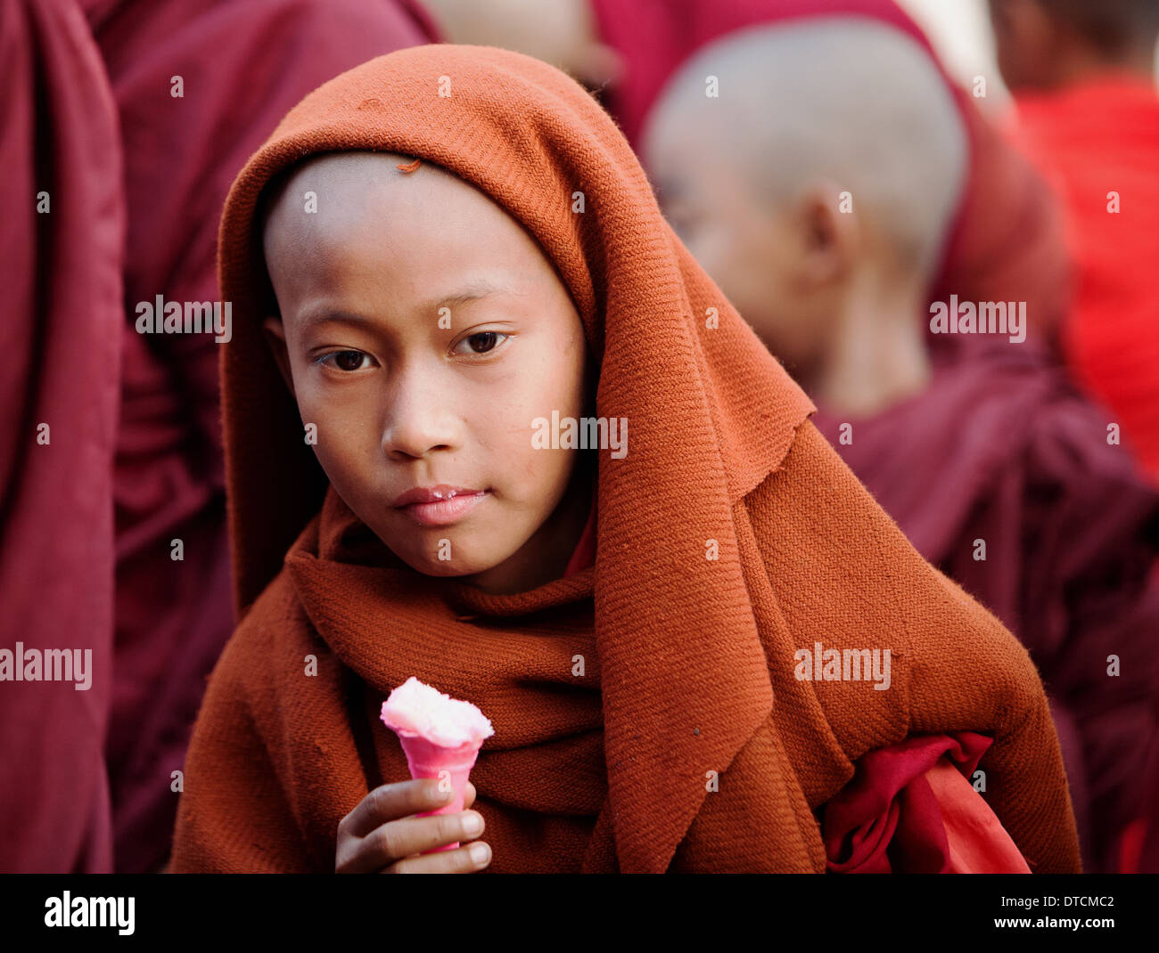A boy monk at The Ananda Pagado Festival in Bagan eating an ice cream ...