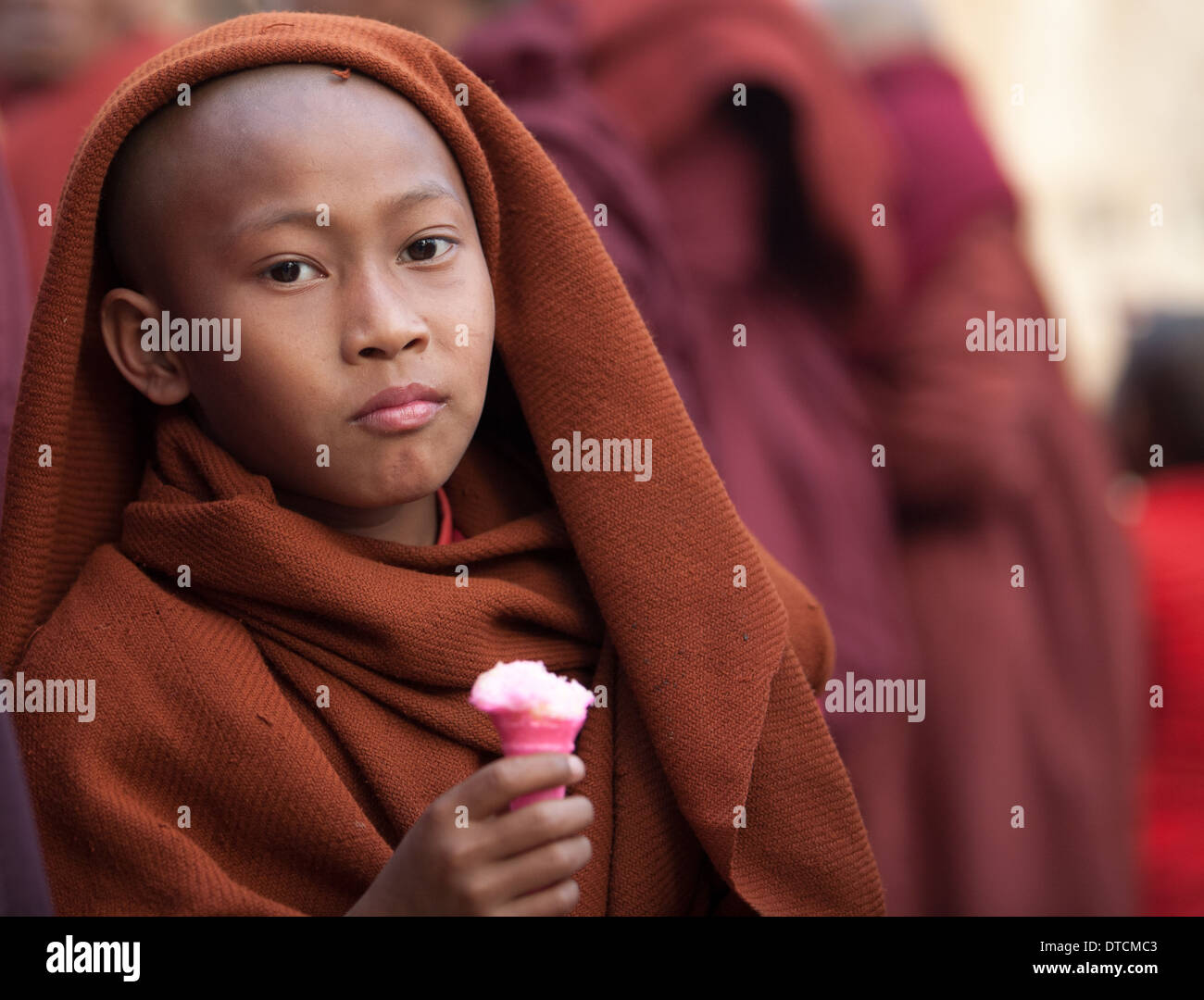 A boy monk at The Ananda Pagado Festival in Bagan eating an ice cream ...