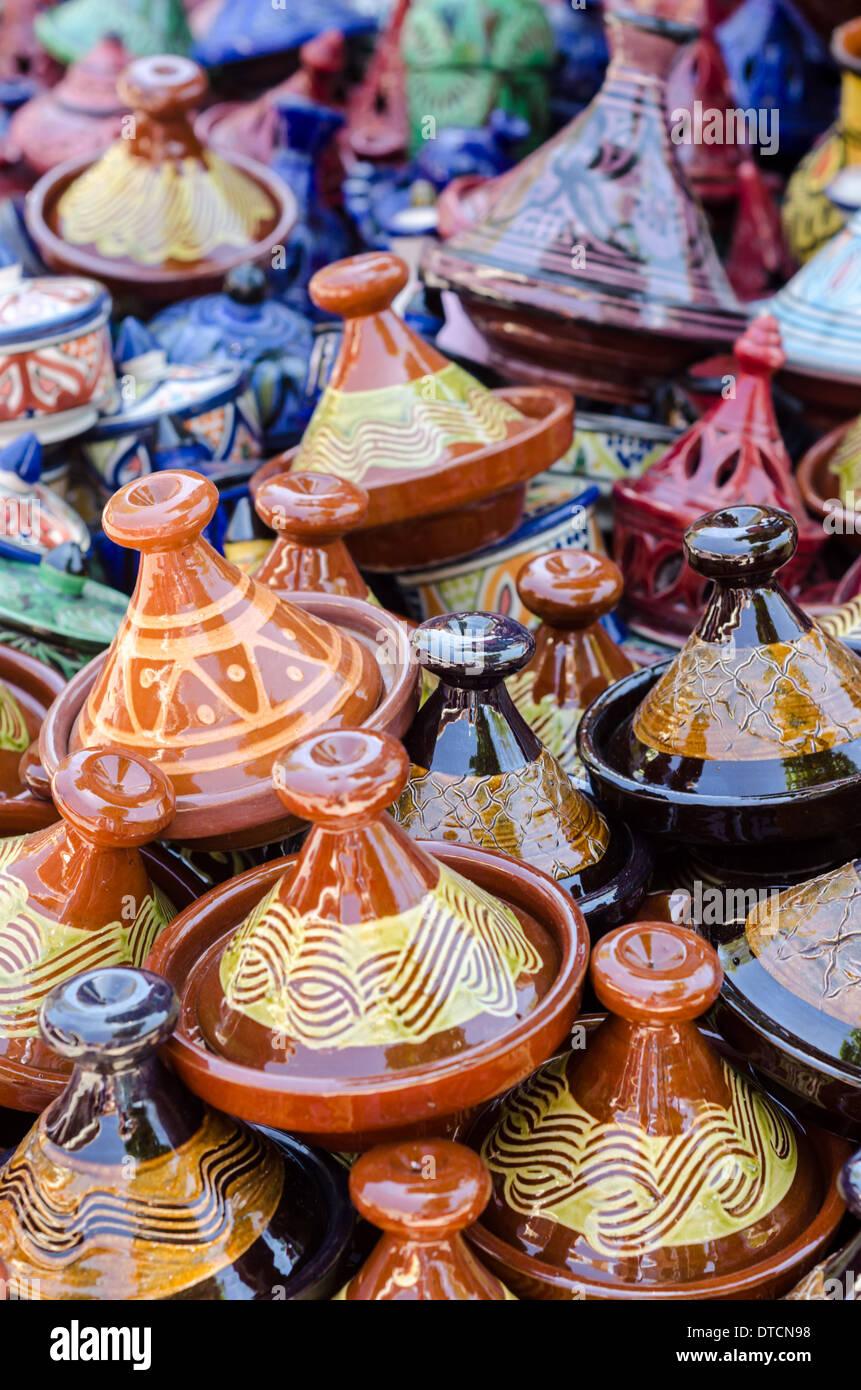Small brightly-colored glazed pottery tajines stacked on display in a ...