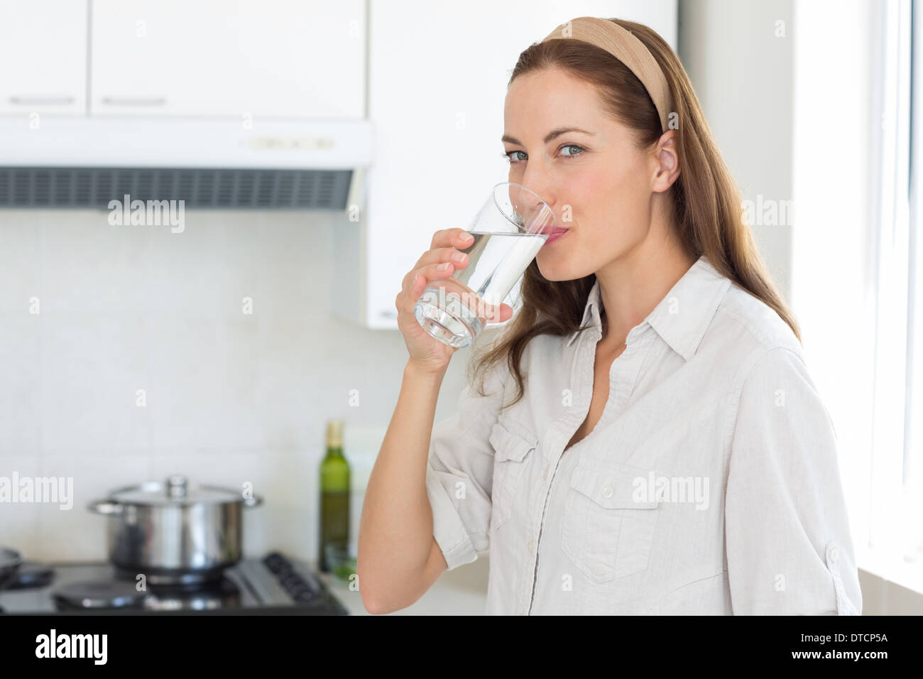 Portrait of a woman drinking water in kitchen Stock Photo - Alamy
