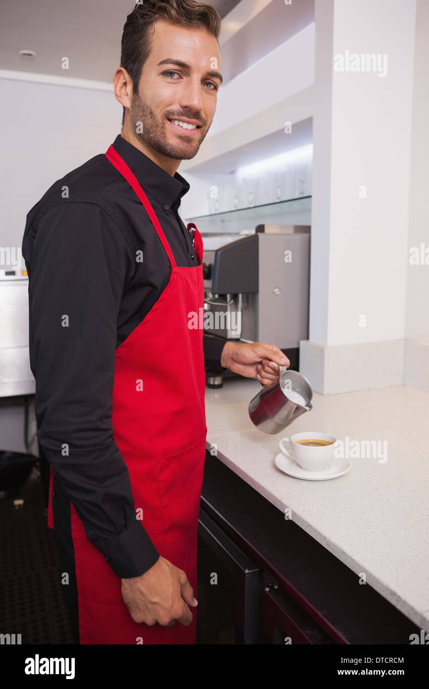 Happy barista pouring milk into cup of coffee Stock Photo - Alamy