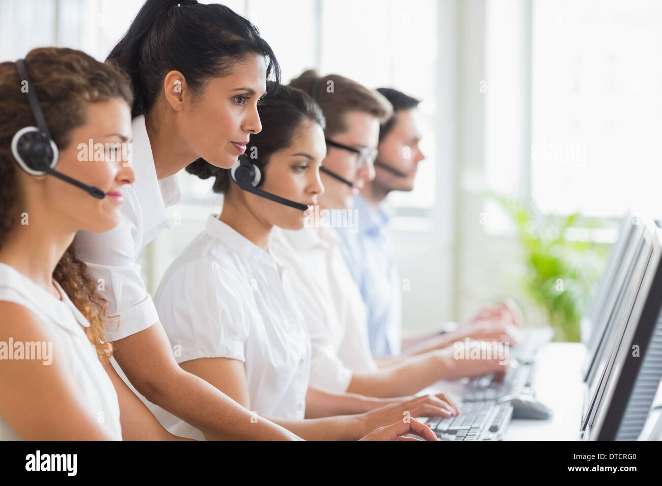 Manager assisting her staffs in call center Stock Photo - Alamy