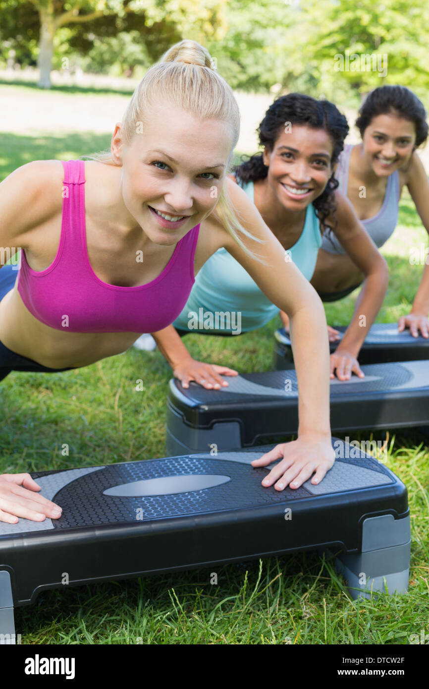 Smiling women doing step aerobics Stock Photo - Alamy