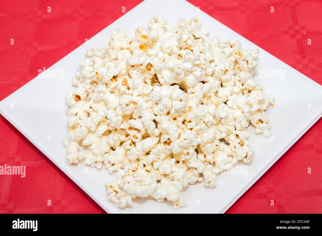 popcorn in a plate on a red background Stock Photo - Alamy