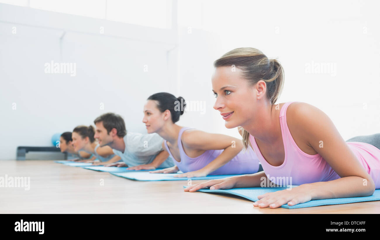 Class exercising in row at fitness studio Stock Photo - Alamy