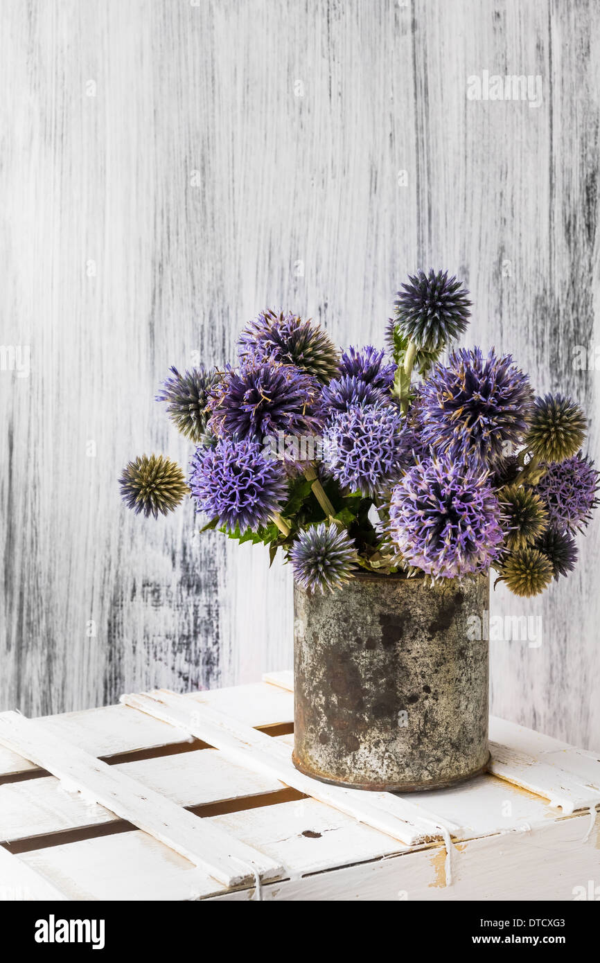 Still life with sunflower on matalic rusty cup on white wooden ...