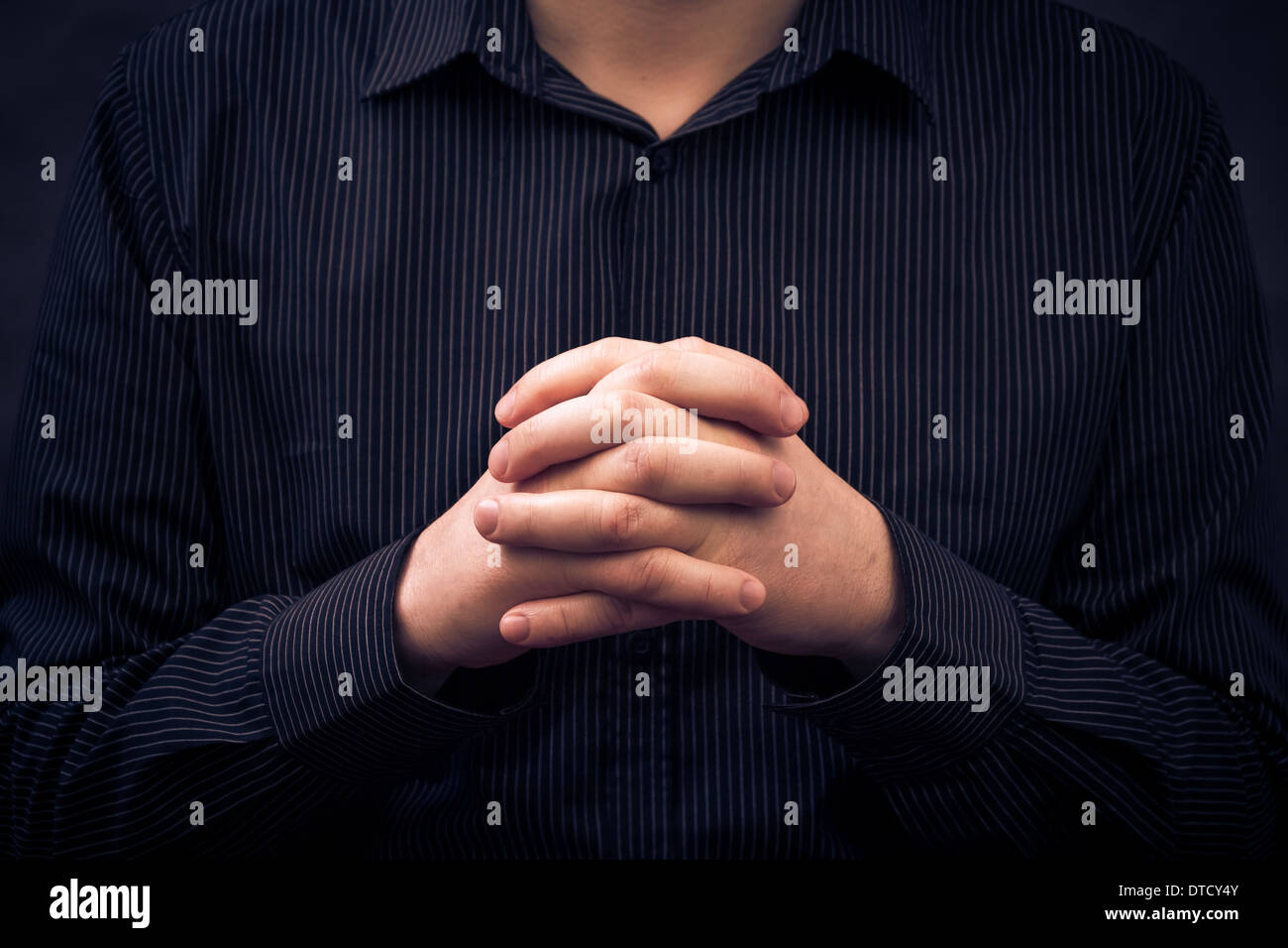 A man wearing a shirt with folded hands Stock Photo - Alamy