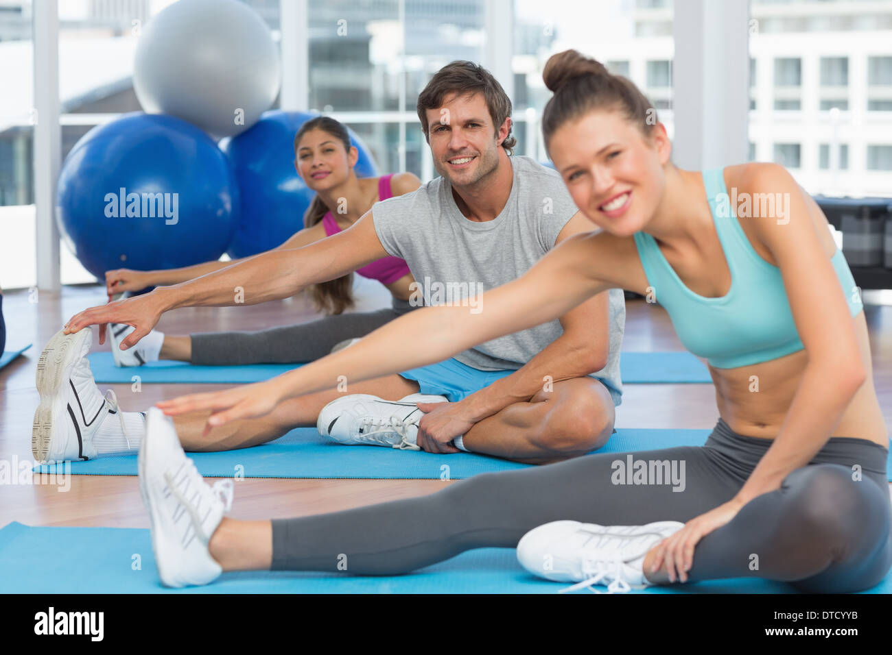 Smiling people doing stretching exercises Stock Photo - Alamy