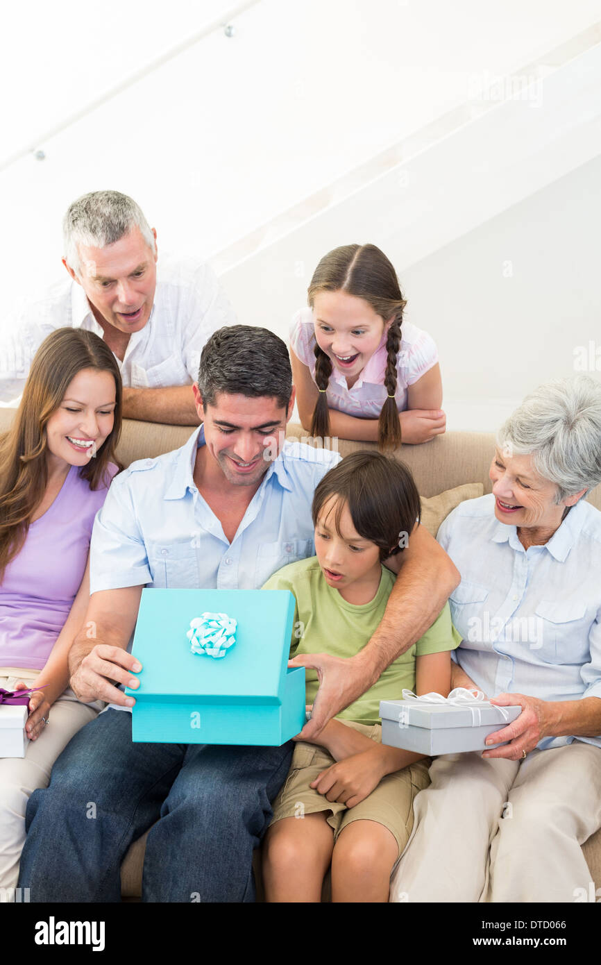 Family gifting birthday present to man Stock Photo - Alamy